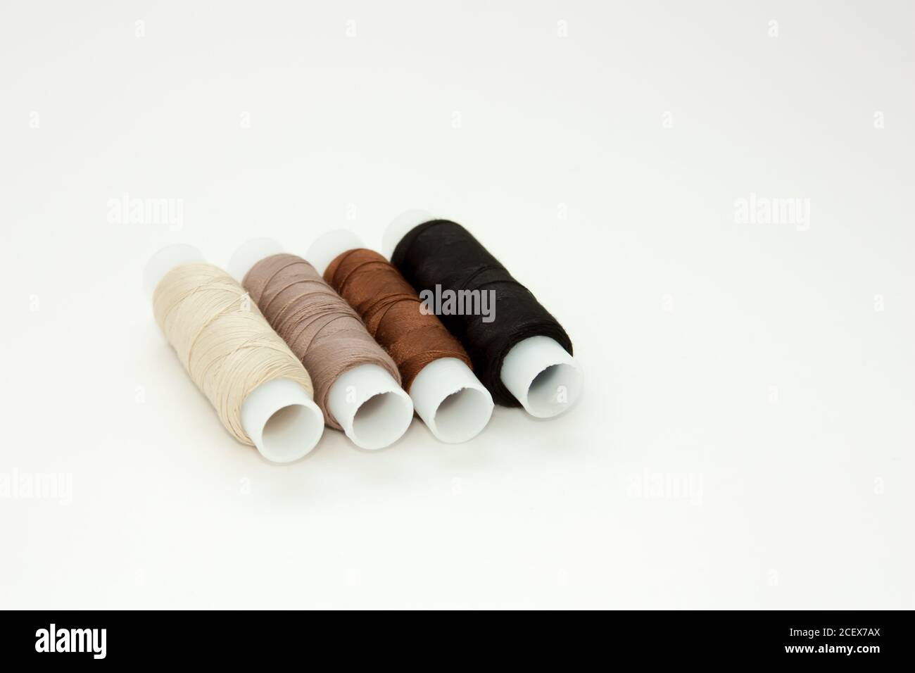 Flat lay colorful cotton thread spools, embroidery yarn, white, brown ...