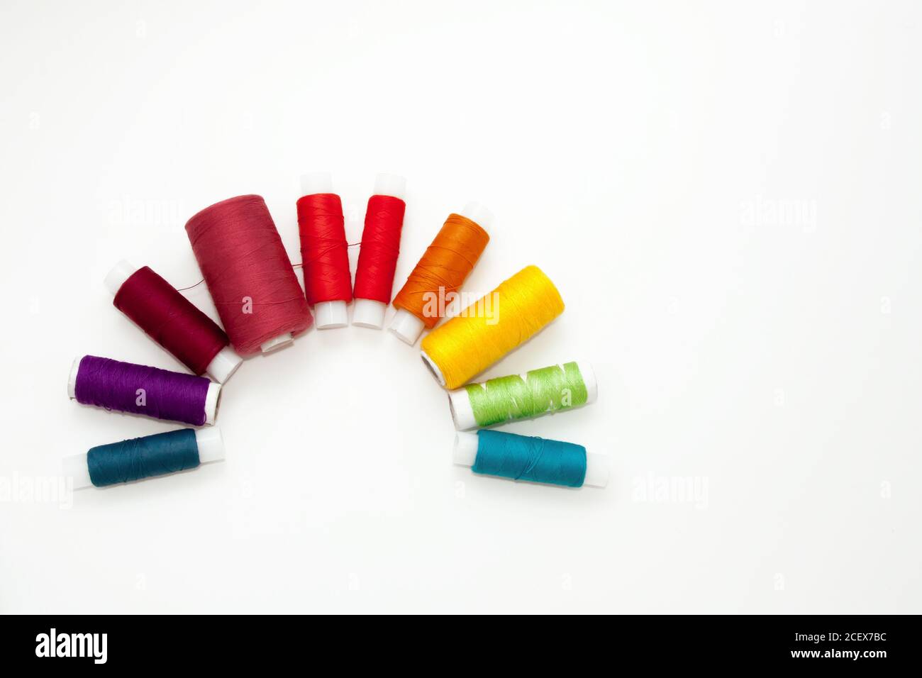 Flat lay with colorful cotton thread spools, embroidery yarn, rainbow ...