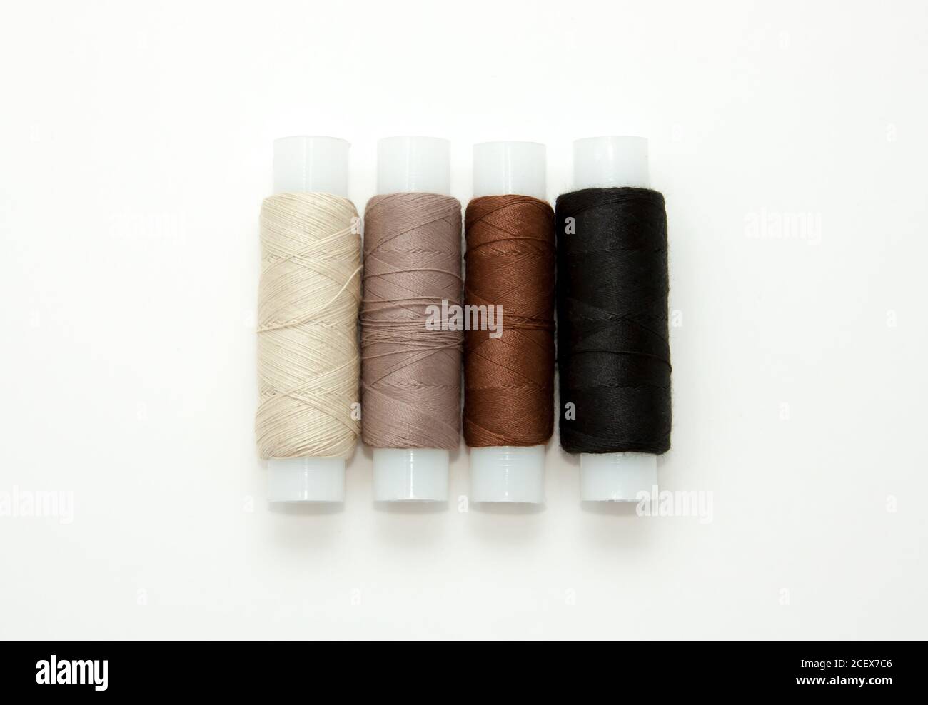Flat lay colorful cotton thread spools, embroidery yarn, white, brown ...