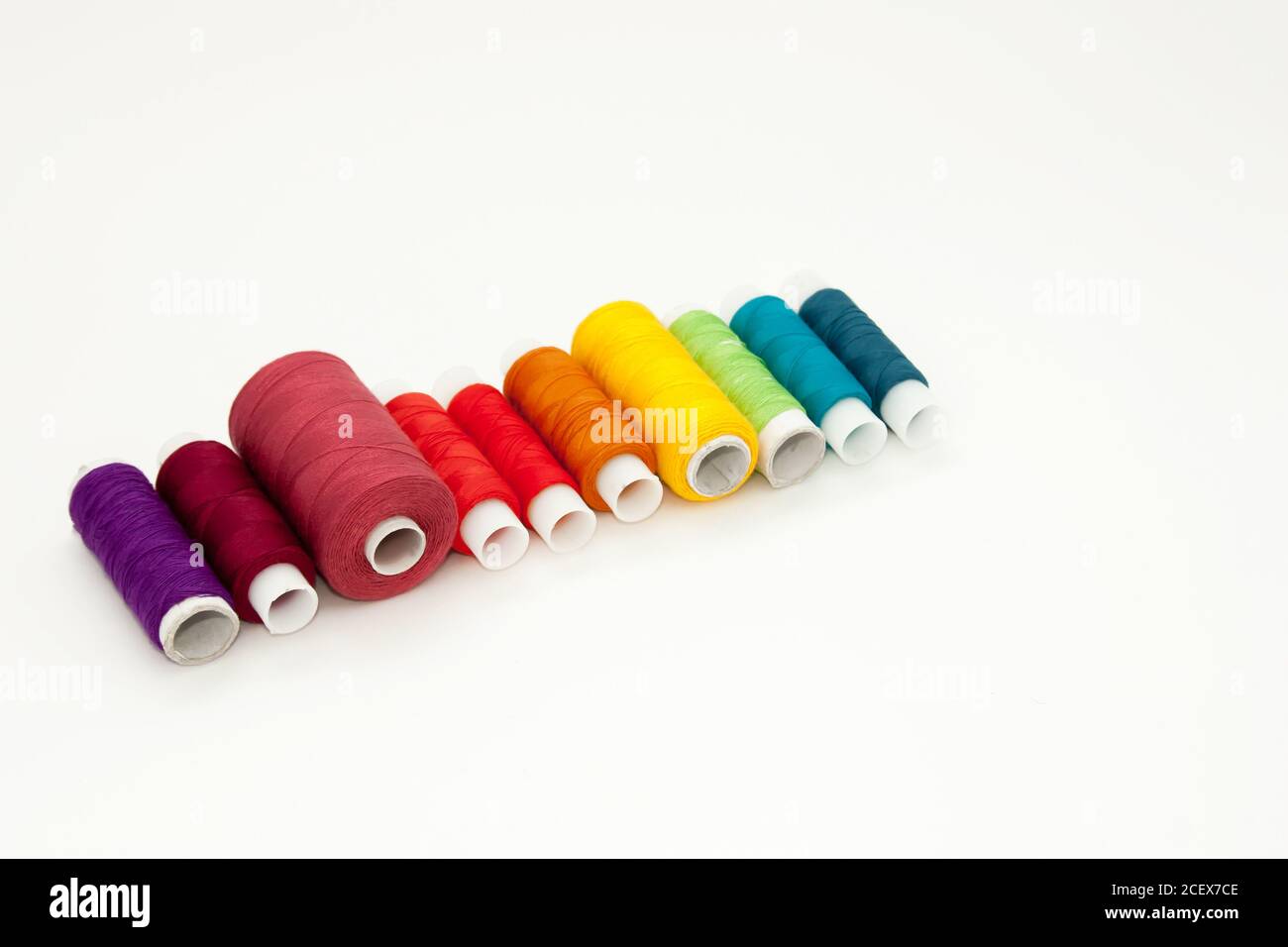 Flat lay with colorful cotton thread spools, embroidery yarn, rainbow ...