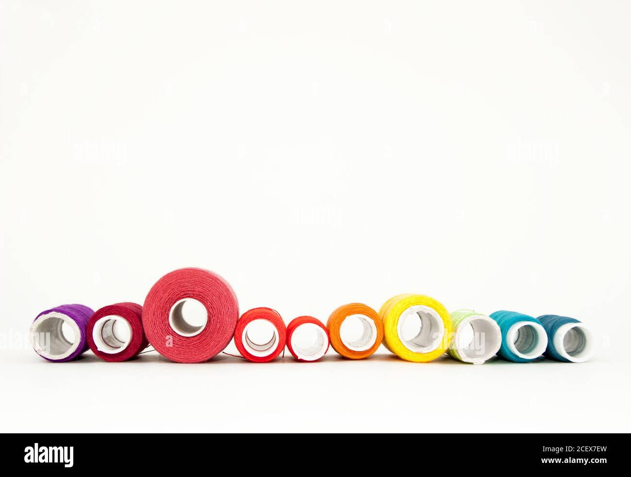 Flat lay with colorful cotton thread spools, embroidery yarn, rainbow ...