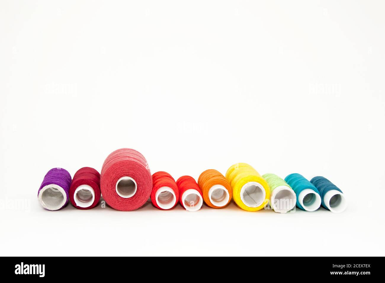 Flat lay with colorful cotton thread spools, embroidery yarn, rainbow ...