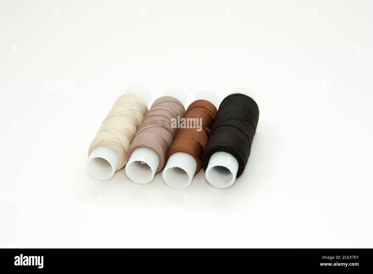 Flat lay colorful cotton thread spools, embroidery yarn, white, brown ...