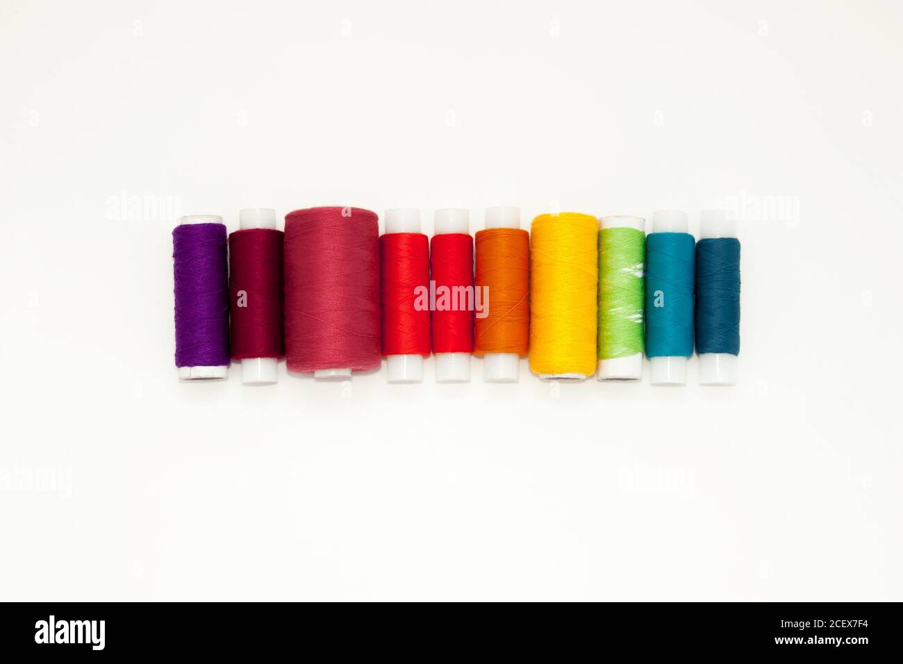 Flat lay with colorful cotton thread spools, embroidery yarn, rainbow ...