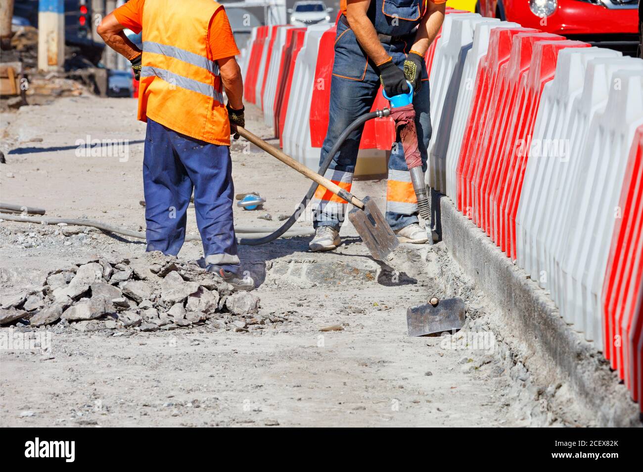 Workers repairing an old section of the road using a pneumatic ...