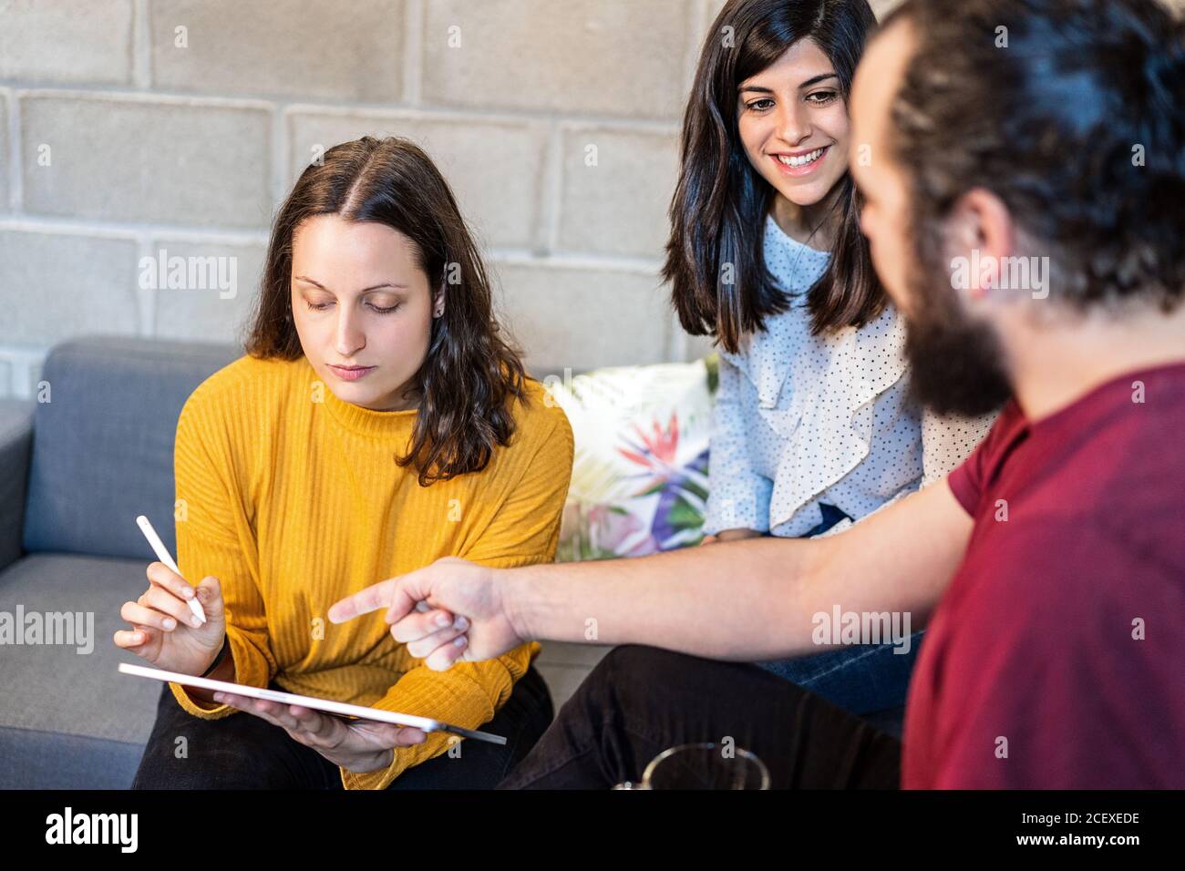 Group of creative millennial designers drinking coffee and discussing ...