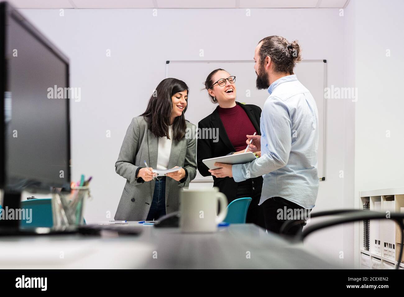 Group of positive young colleagues in formal clothes gathering in ...