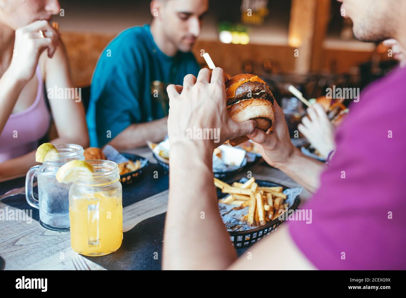 Cheerful friends having fun in fast food cafe Stock Photo - Alamy