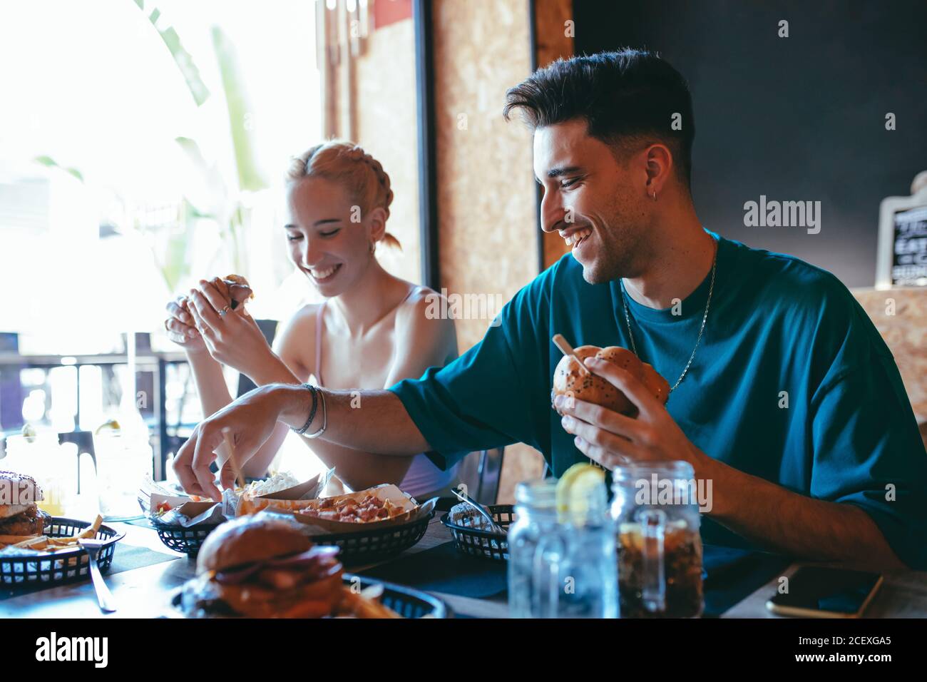 Cheerful friends having fun in fast food cafe Stock Photo - Alamy