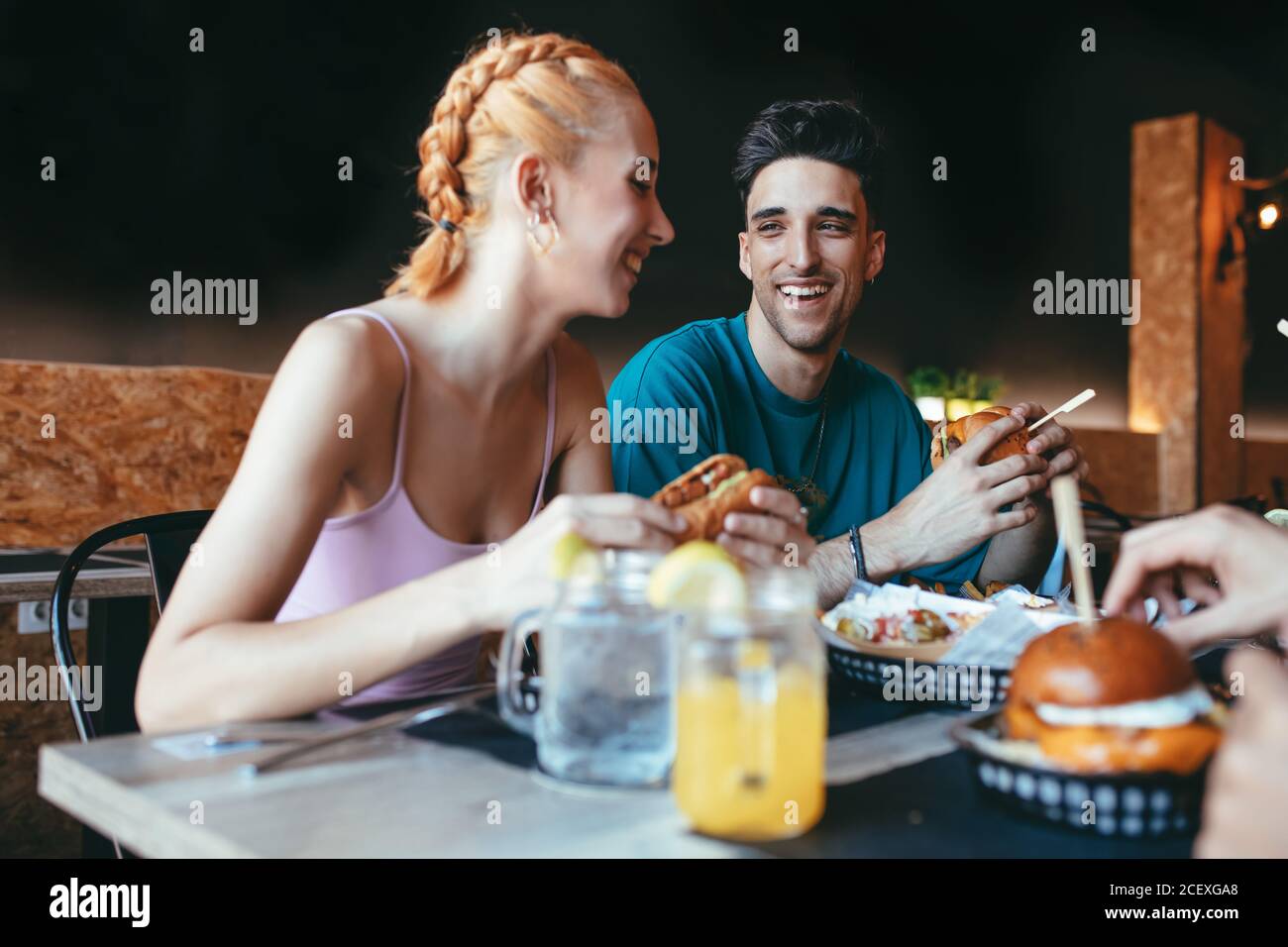Cheerful friends having fun in fast food cafe Stock Photo - Alamy