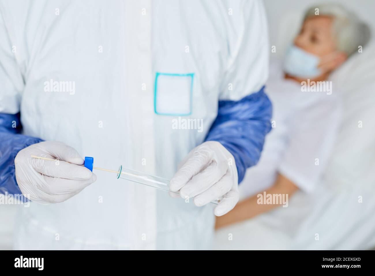 Unrecognizable doctor in uniform putting swab sample stick into test ...