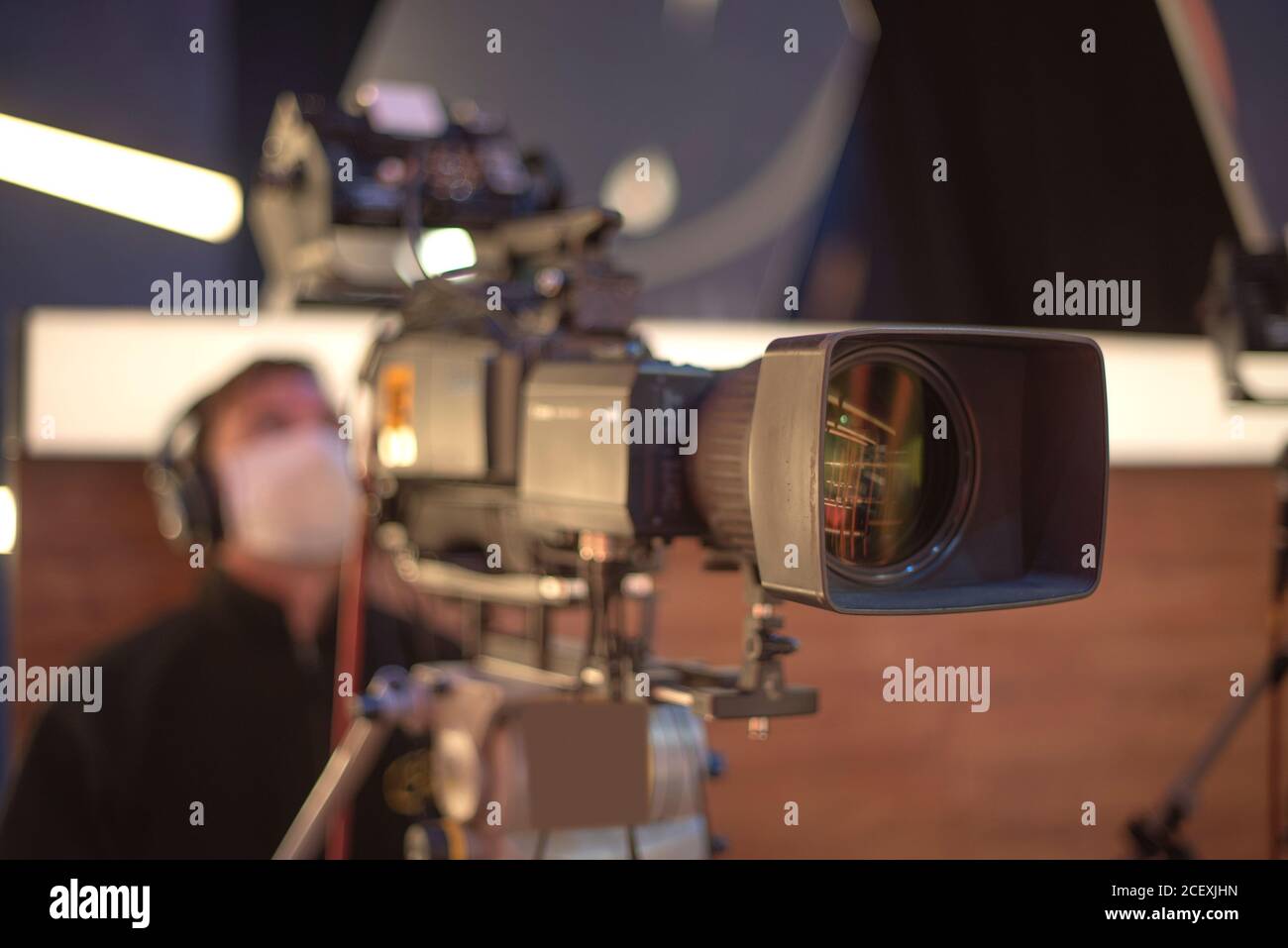 masked cameraman is filming a television show in the studio. TV Stock ...