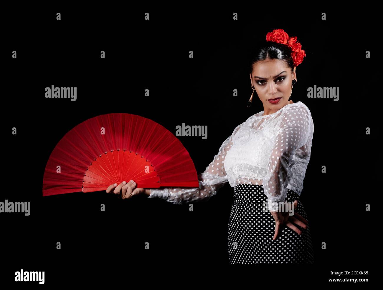 Full body young Hispanic female dancer in colorful costume with red fan ...