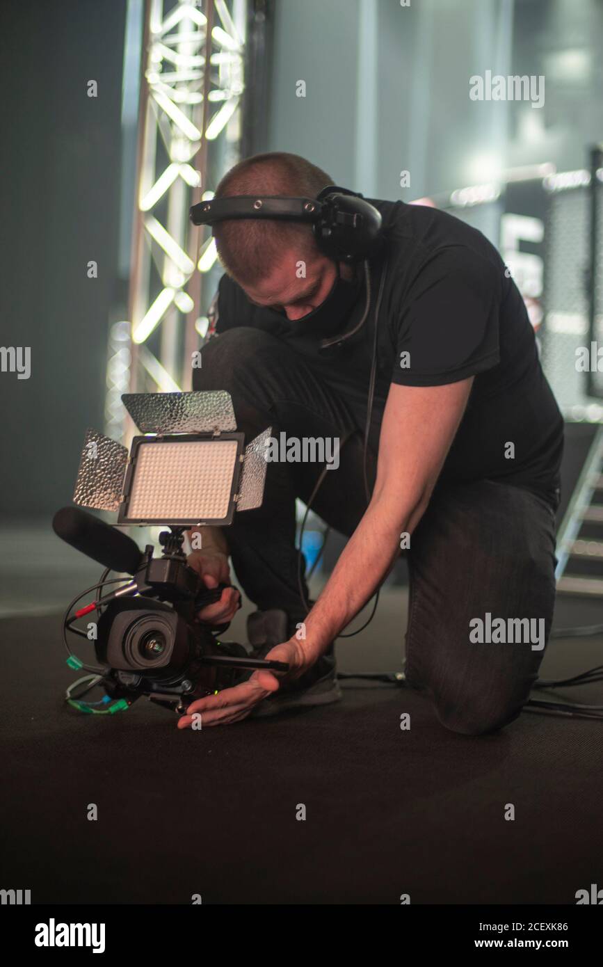 masked cameraman is filming a television show in the studio. TV Stock ...
