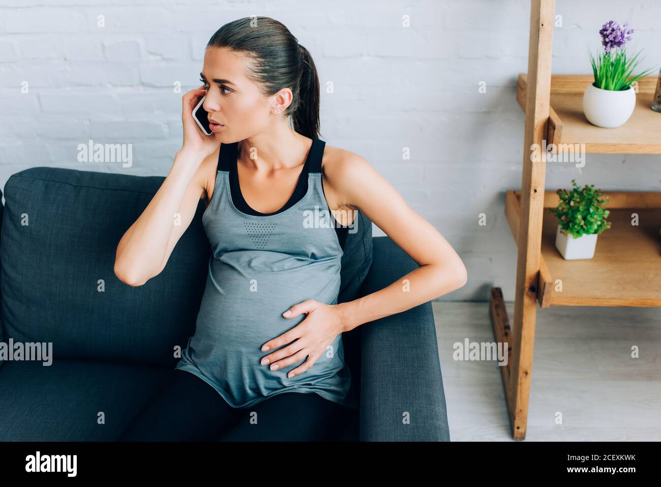 Pregnant sportswoman touching belly hi-res stock photography and images ...