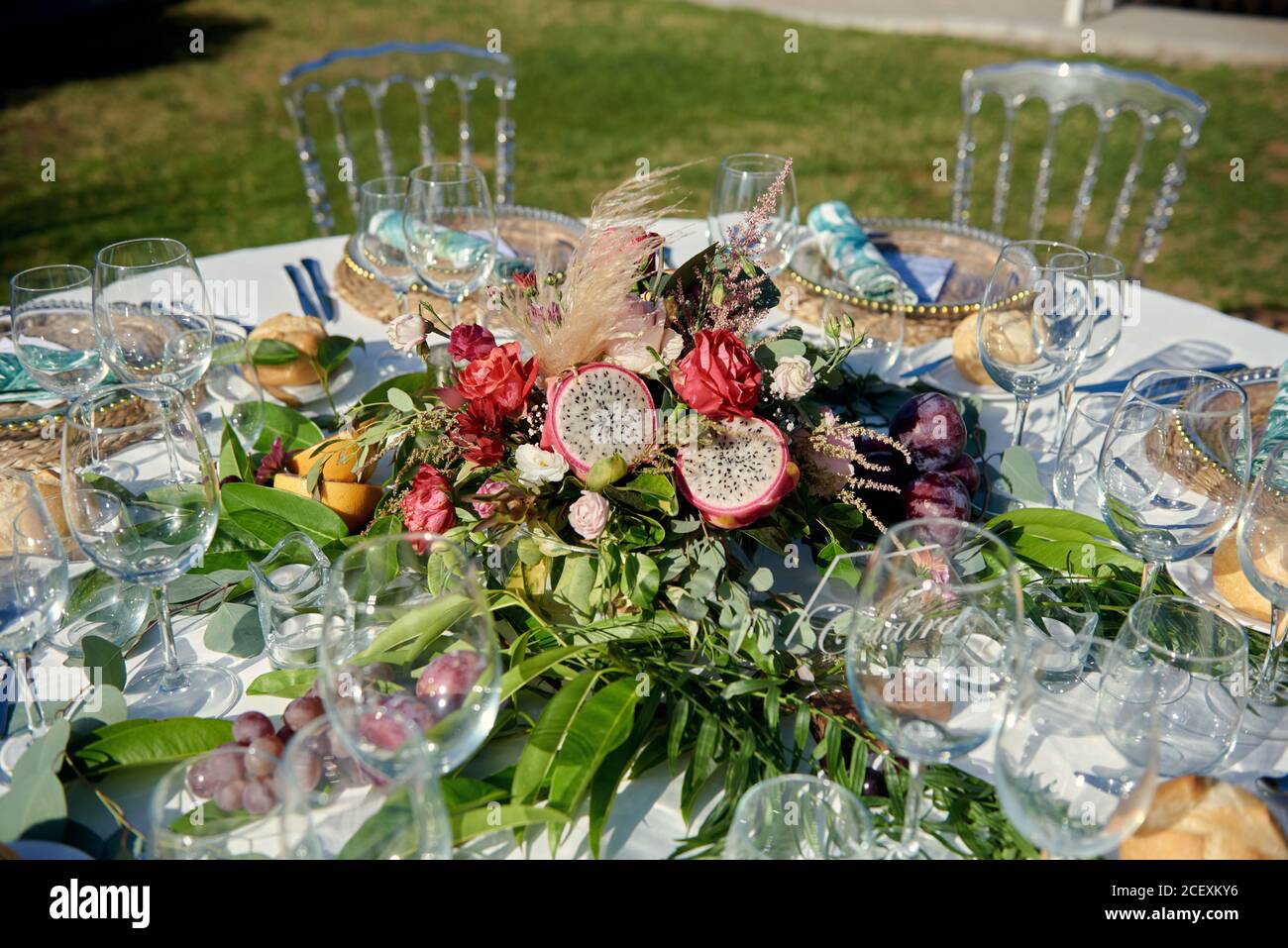 Round table with various fruits and flowers surrounded by chairs and ...