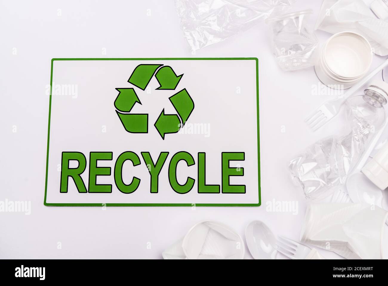 top view of recycle card and plastic rubbish scattered on white ...