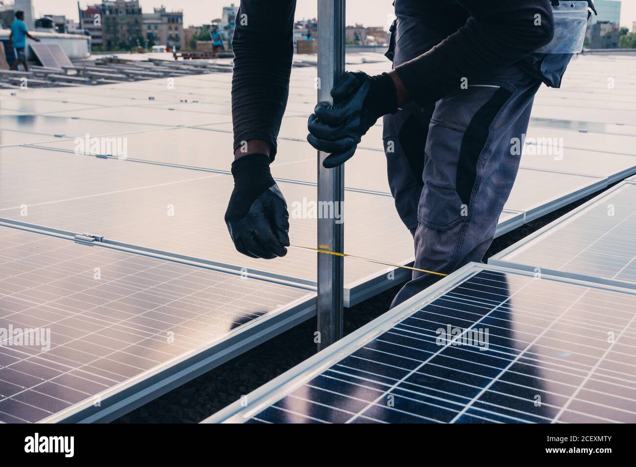 Workman in protective uniform installing modern solar panels on roof of ...