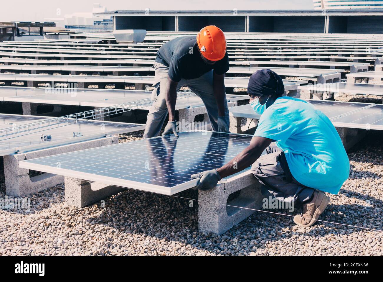 Busy black male engineers installing solar batteries in construction ...