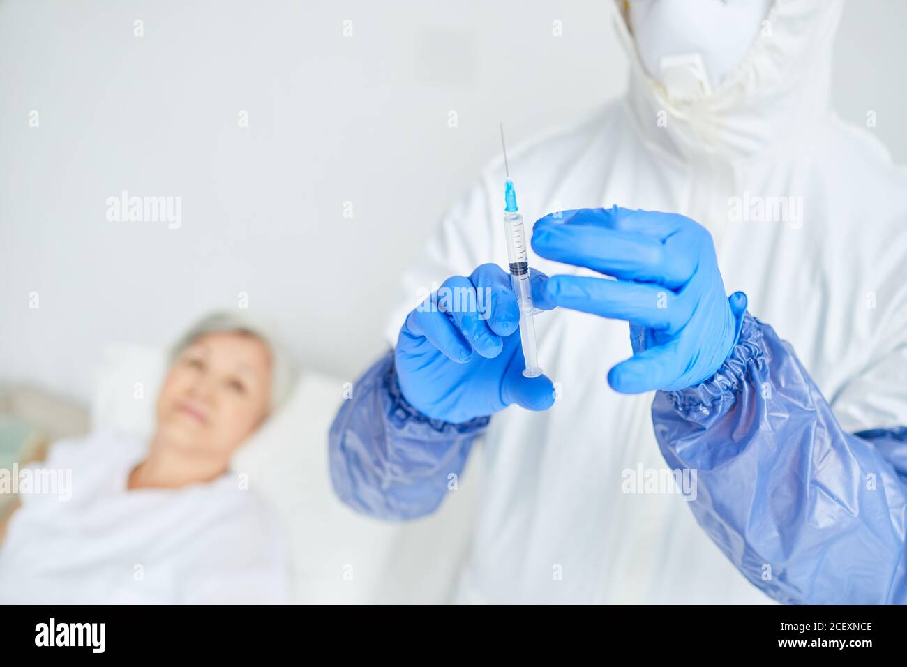 Unrecognizable doctor wearing protective suit and gloves preparing ...