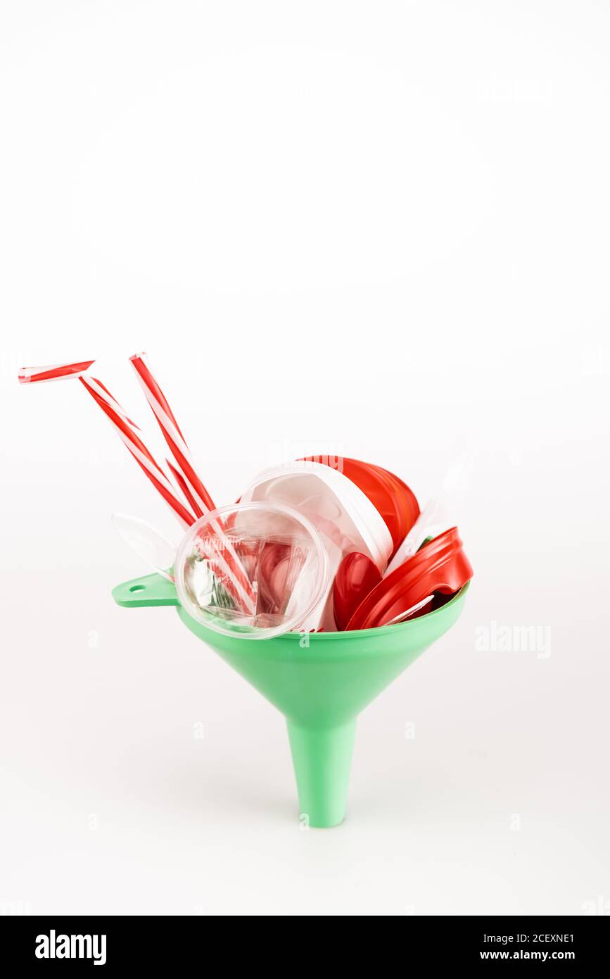 red plastic objects in funnel on white background Stock Photo - Alamy