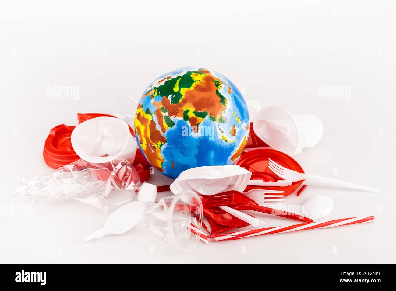 plastic trash scattered around globe on white background Stock Photo ...