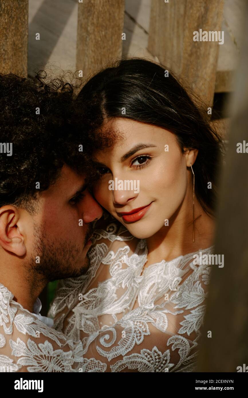 High angle of sensual newlywed couple in stylish clothing cuddling ...