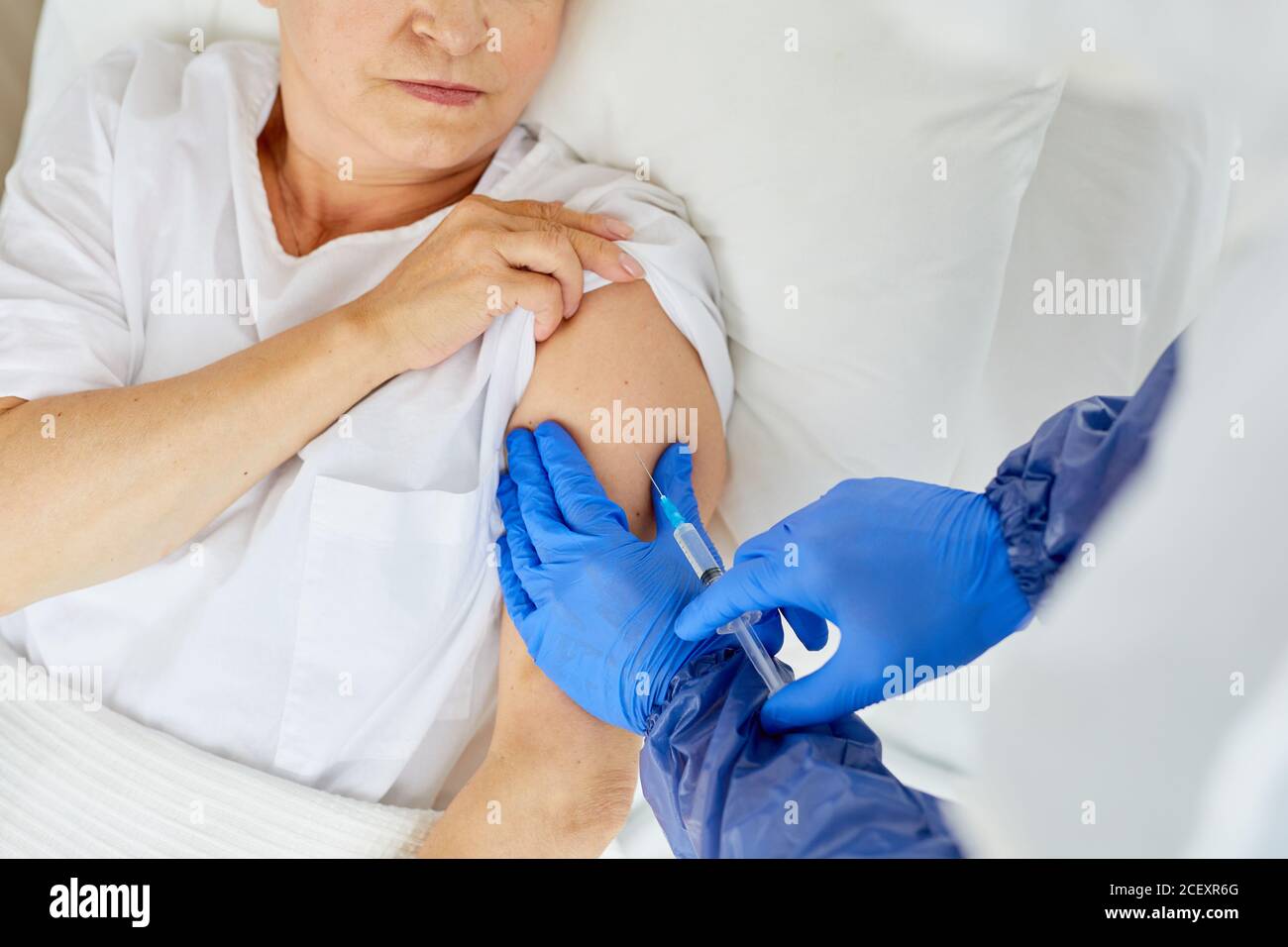 High angle view shot of doctor giving antiviral injection to mature ...