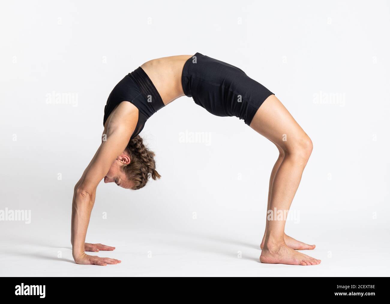 Full body side view of young slim female in sportswear performing ...