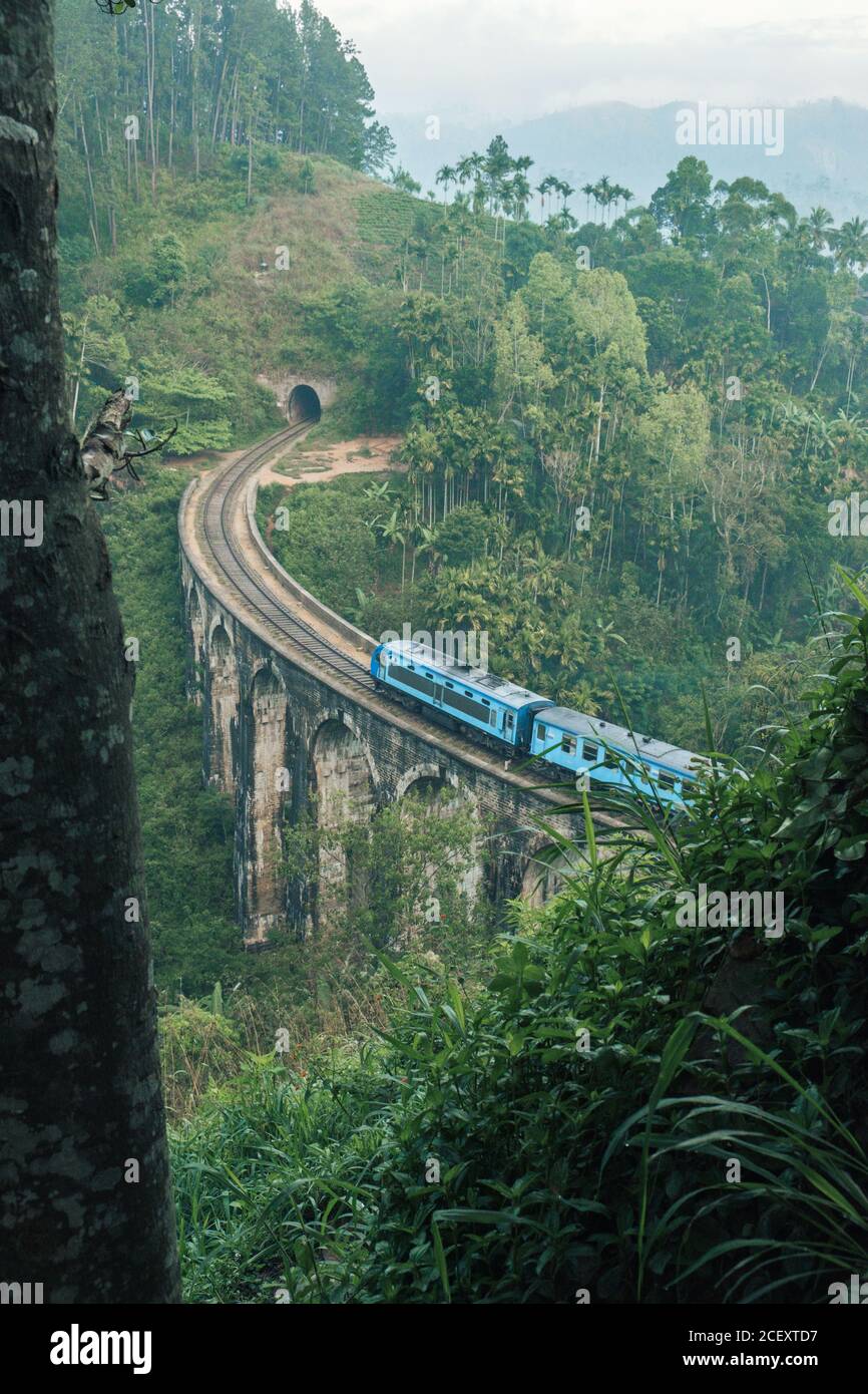 From above of blue train running on aged Nine Arch Bridge located ...