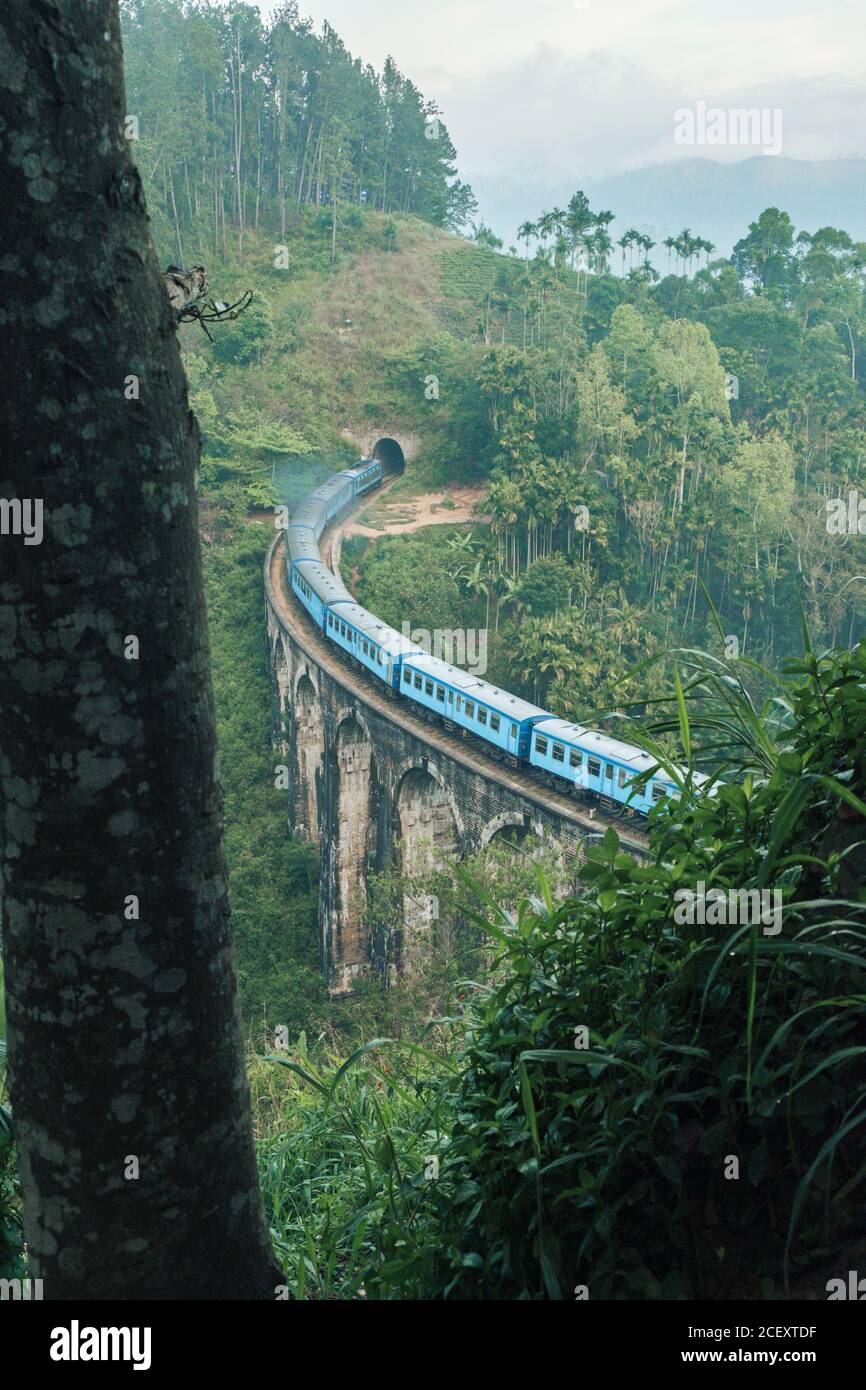 From above of blue train running on aged Nine Arch Bridge located ...