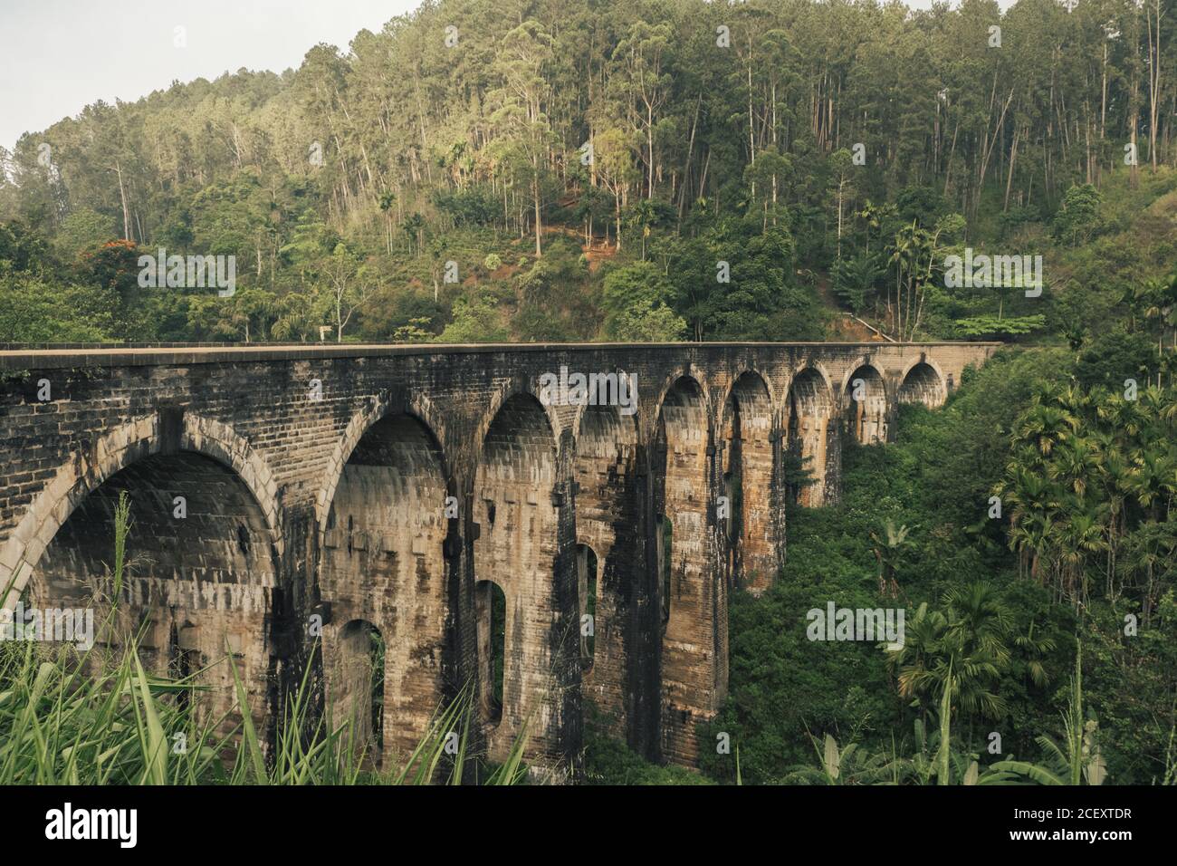 Colonial stone viaduct Nine Arch Bridge leading through green hilly ...