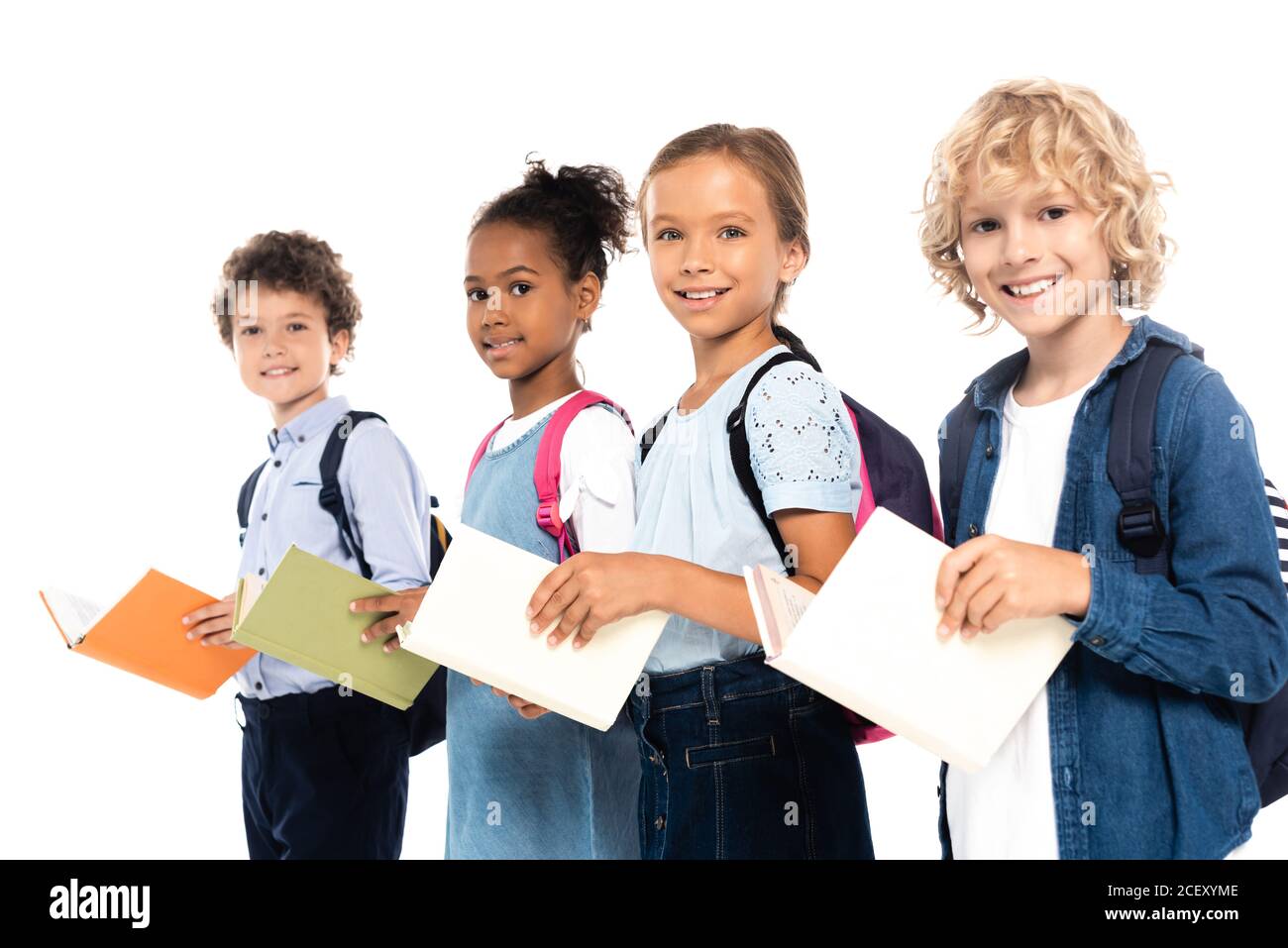 selective focus of multicultural schoolchildren with backpacks holding ...