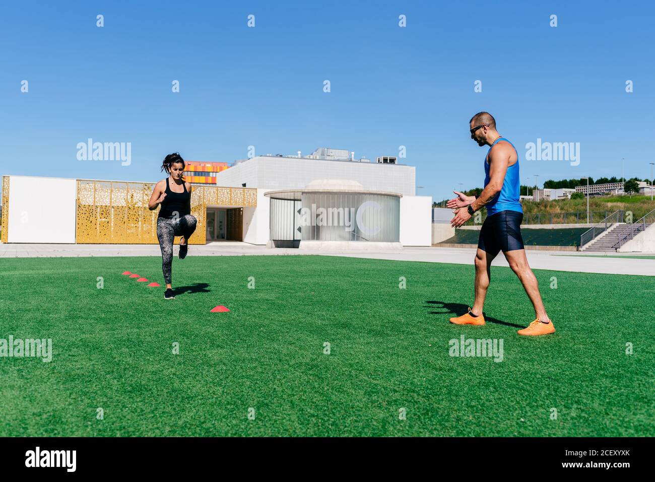 Full body young female athlete jumping on agility ladder during fitness ...