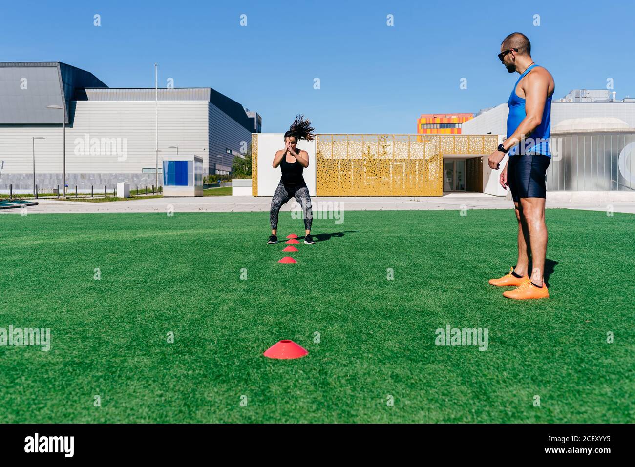 Full body young female athlete jumping on agility ladder during fitness ...