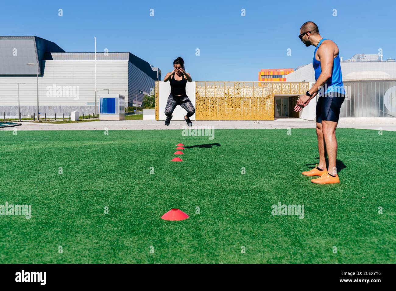 Full body young female athlete jumping on agility ladder during fitness ...