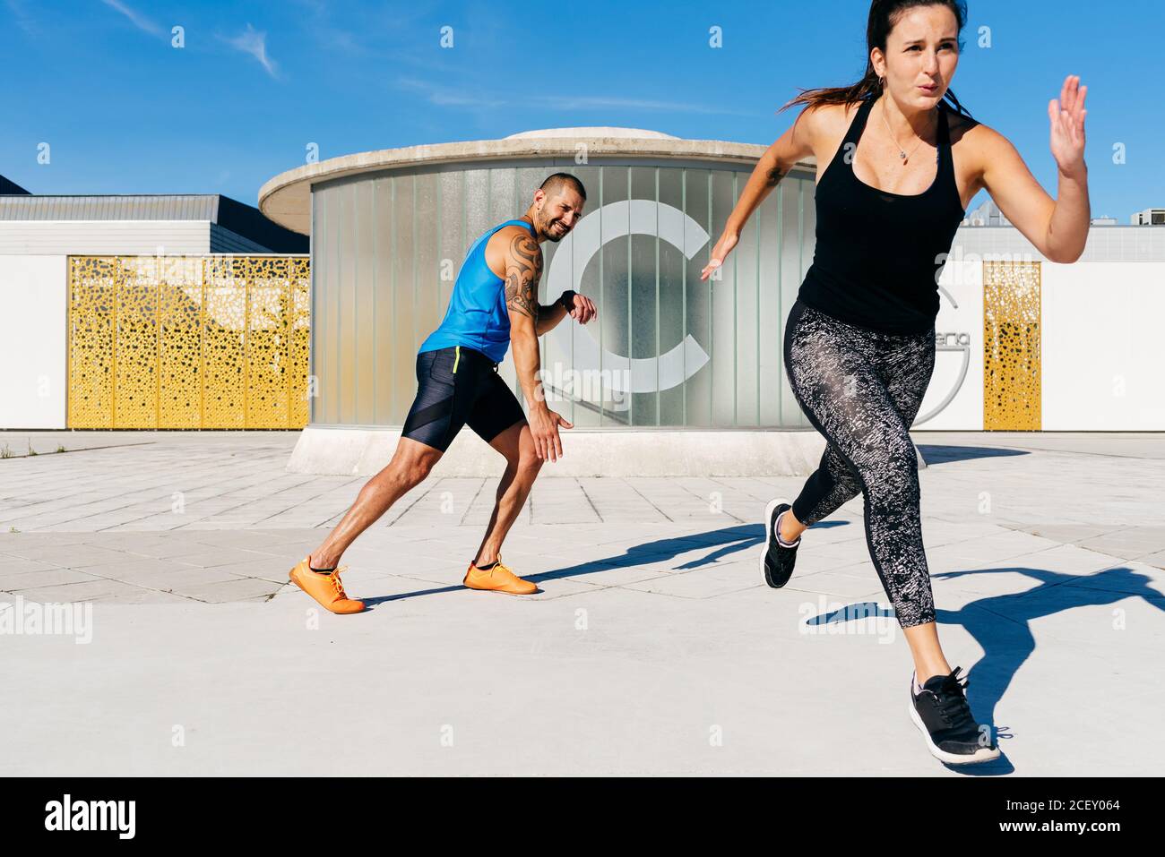 Focused female athlete starting run fast during training with male ...