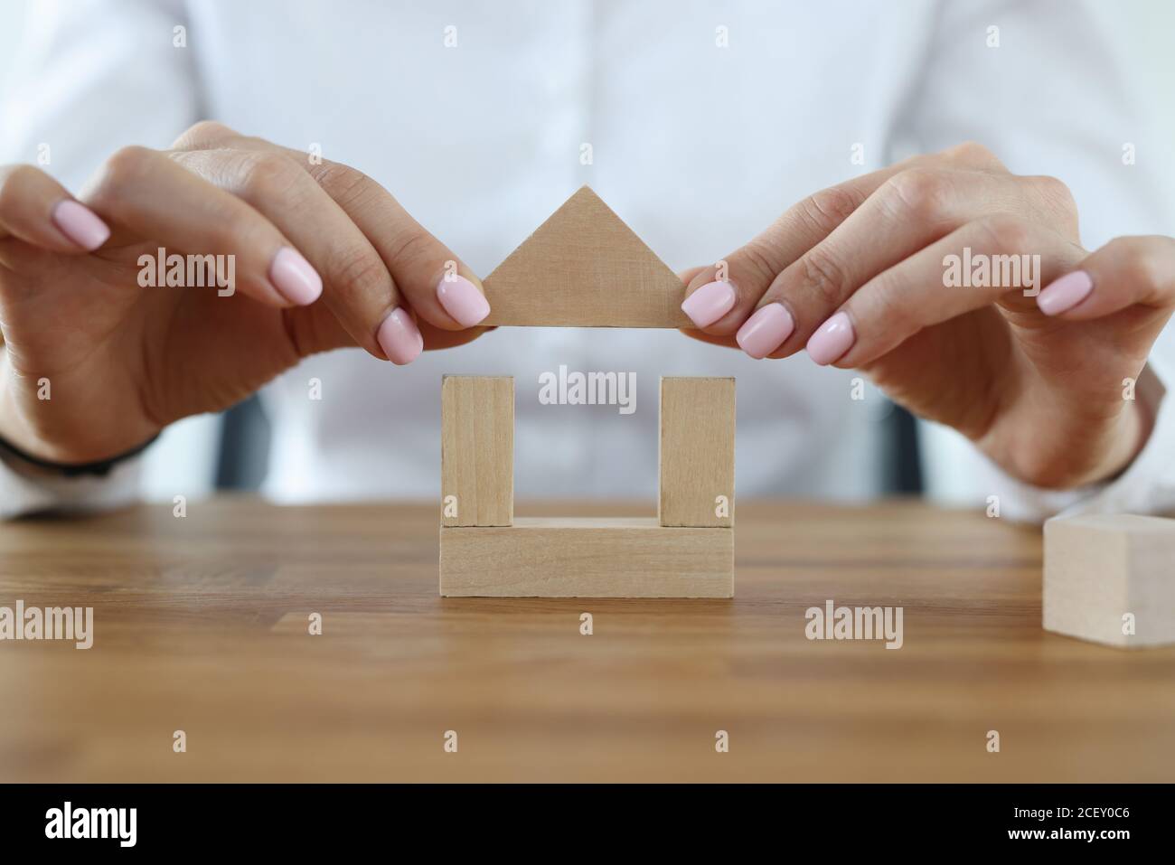 Female hands build house from wooden cubes Stock Photo - Alamy