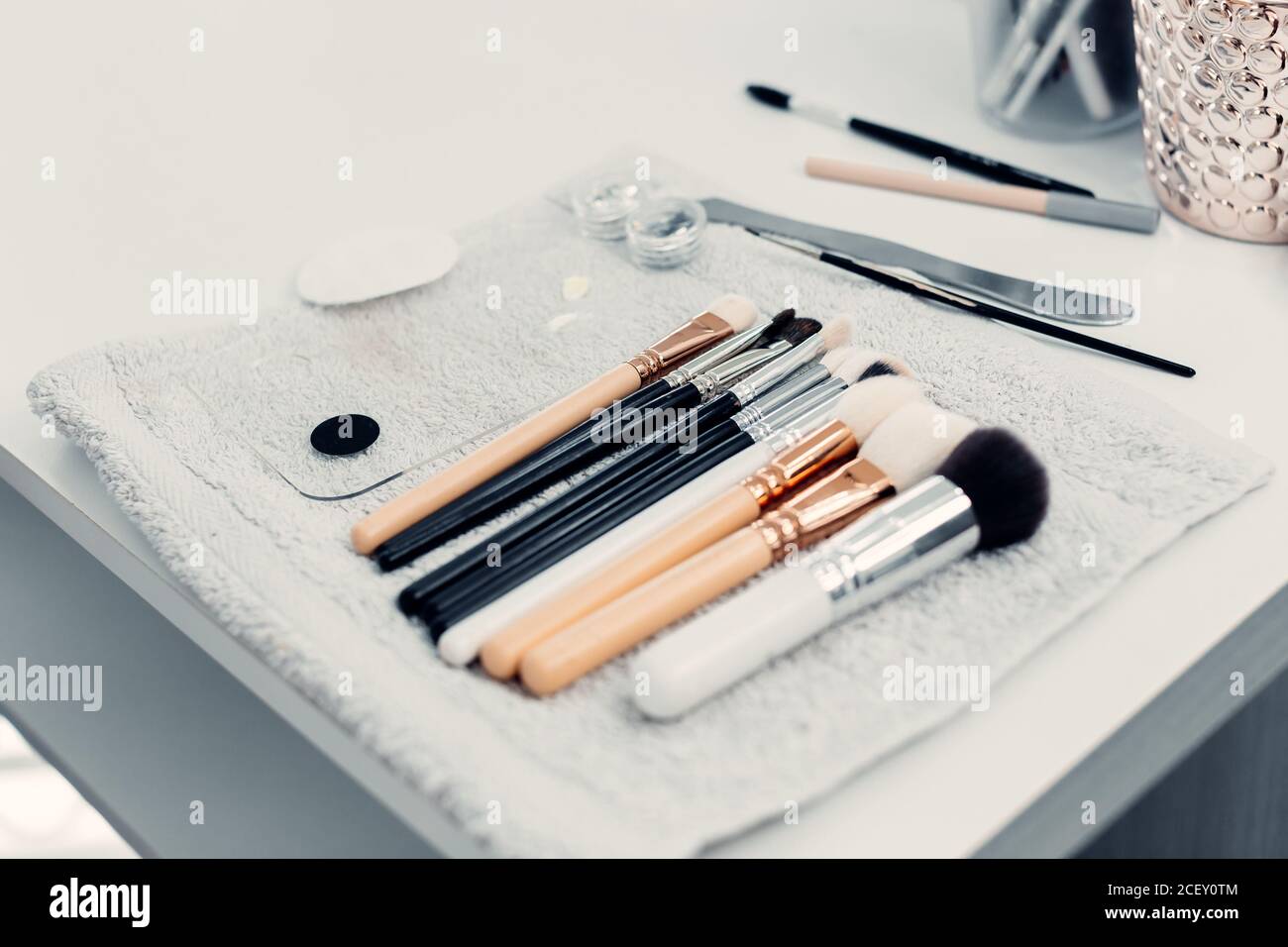 Collection of assorted brushes for makeup arranged on table in bright ...