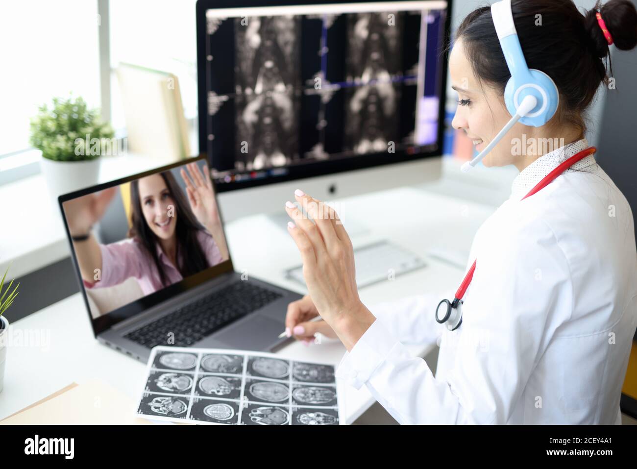 Medical employee operator in headphones with microphone greets hand of ...