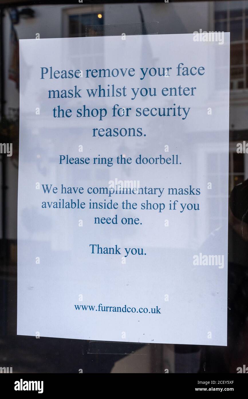 Notice on a jewellers shop door asking people to remove their face ...