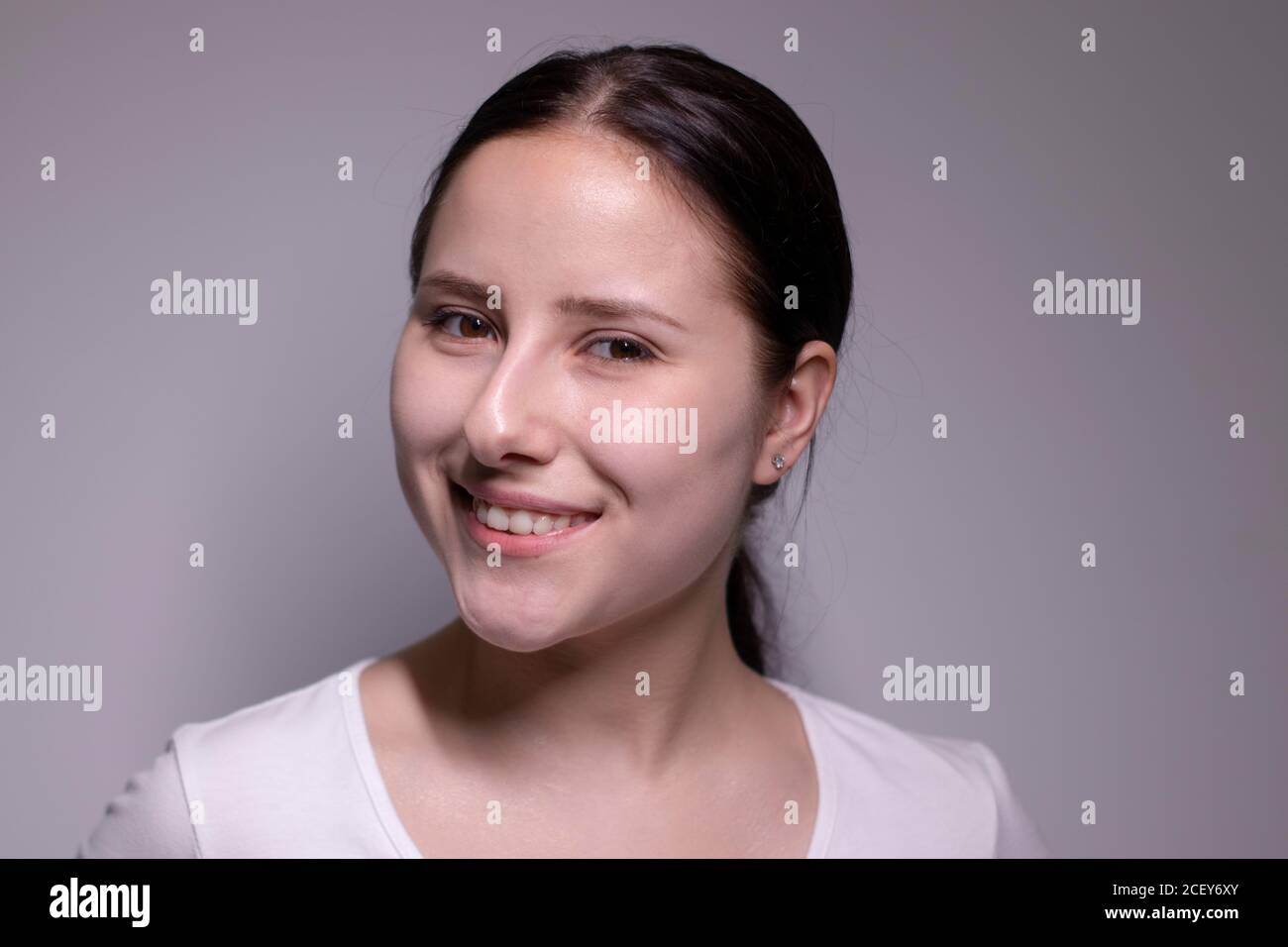 Indoor portrait of Beautiful smiling brunette with clean skin, natural ...