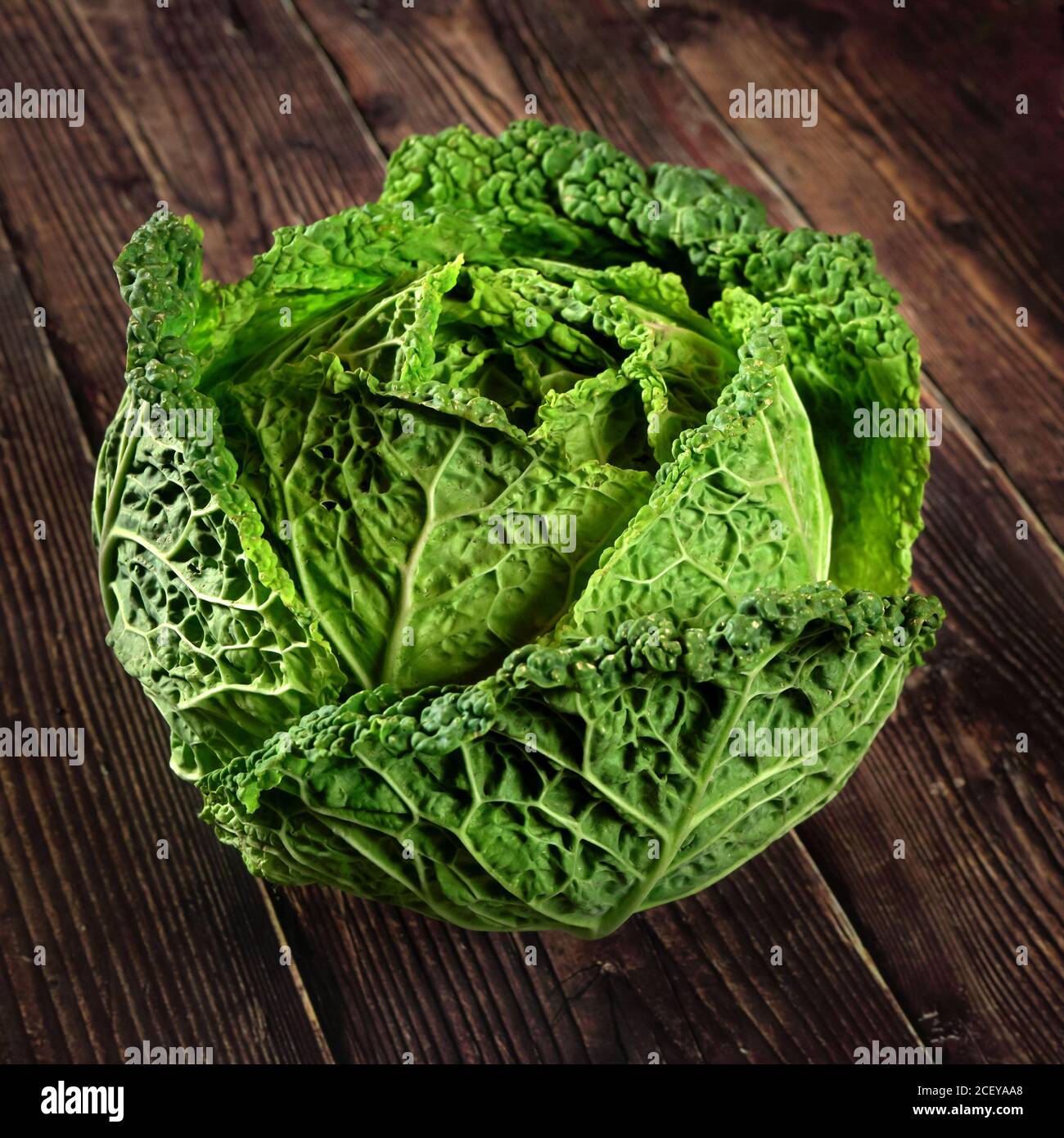 Single green savoy cabbage lettuce head on dark wooden board Stock ...