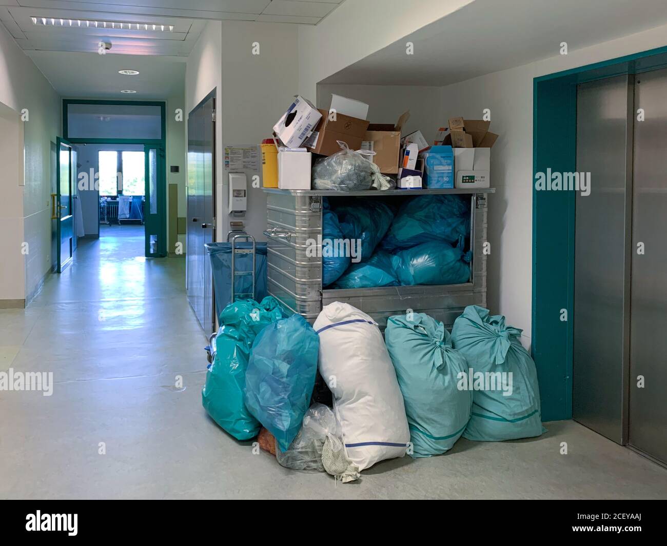 in the corner of a hospital corridor different garbage bags are piled ...