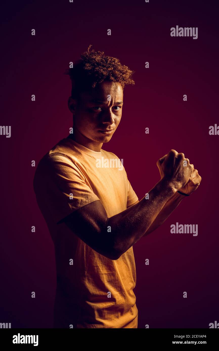 Young adult male showing biceps, looking at camera Stock Photo - Alamy
