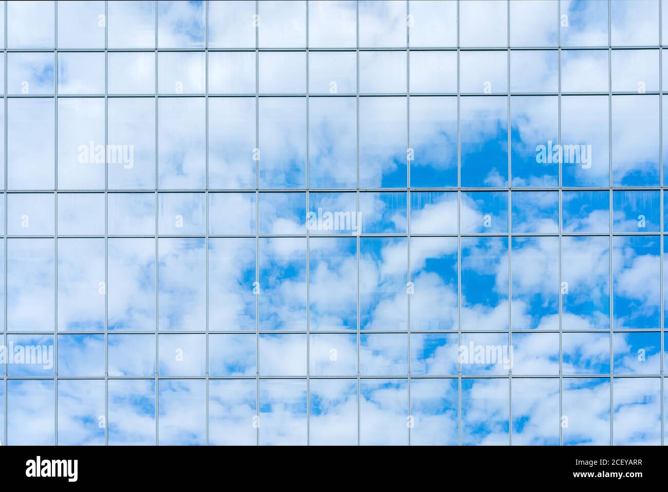 Reflection of the sky and clouds in the glass wall of a high-rise ...