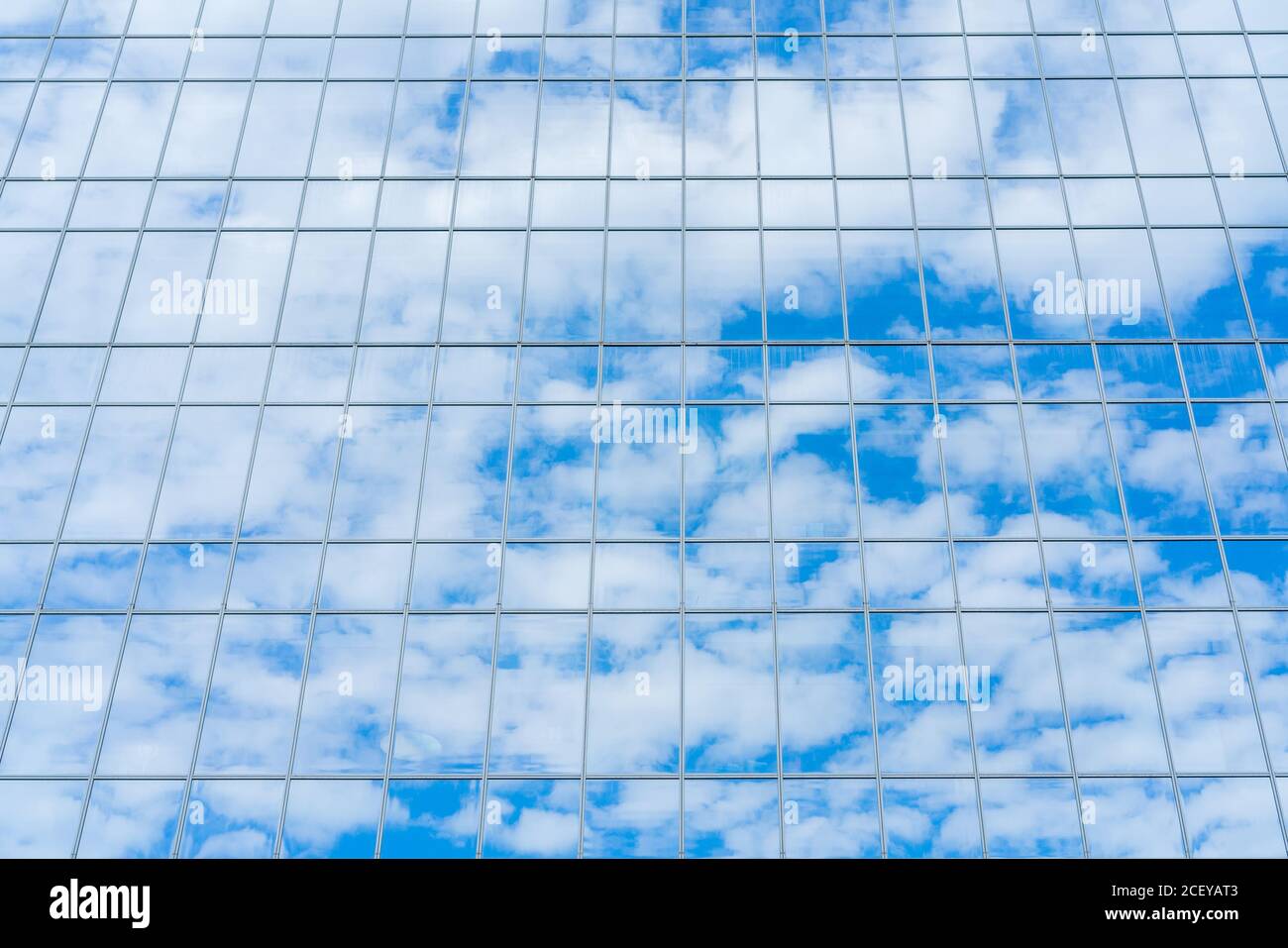 Reflection of the sky and clouds in the glass wall of a high-rise ...