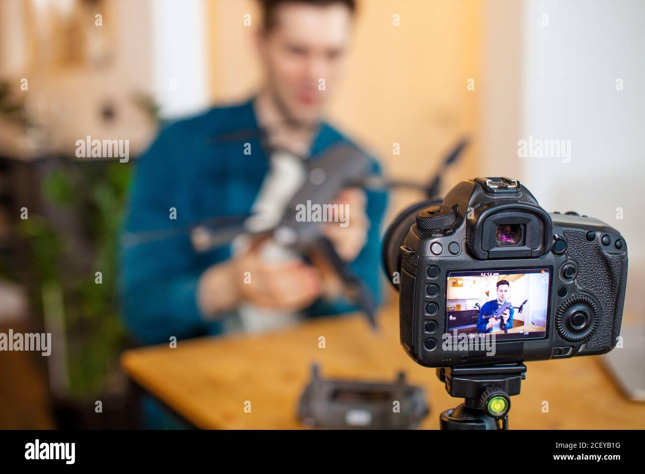 close-up photo of professional camera aimed at young blogger man ...