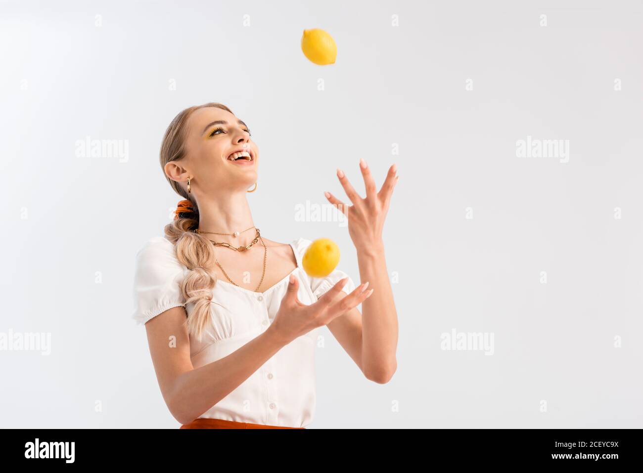 blonde woman juggling with yellow lemons isolated on white Stock Photo ...