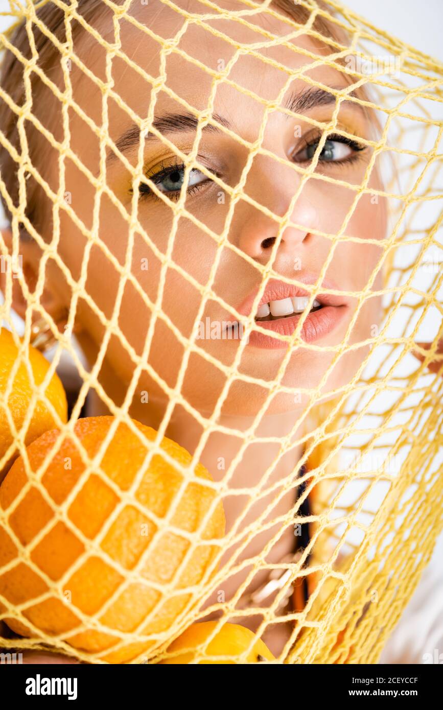 portrait of woman in string bag with citrus fruits Stock Photo - Alamy